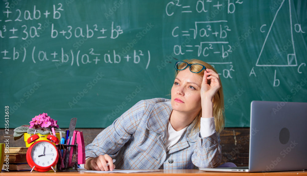 Teacher woman sit table classroom chalkboard background. Teacher busy ...