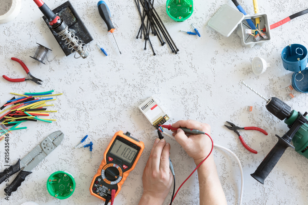 Top view of different electrical tools on white concrete background ...