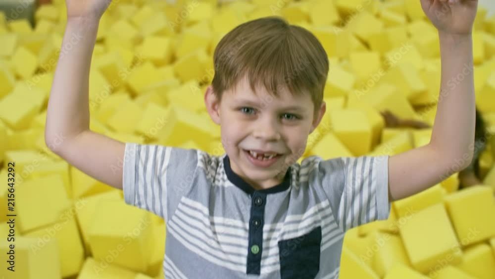 Cute little boy of elementary school age falling backwards into cube ...