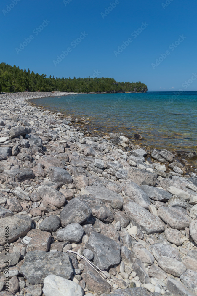 Lake Huron shoreline blue green water and limestone rocks along the ...
