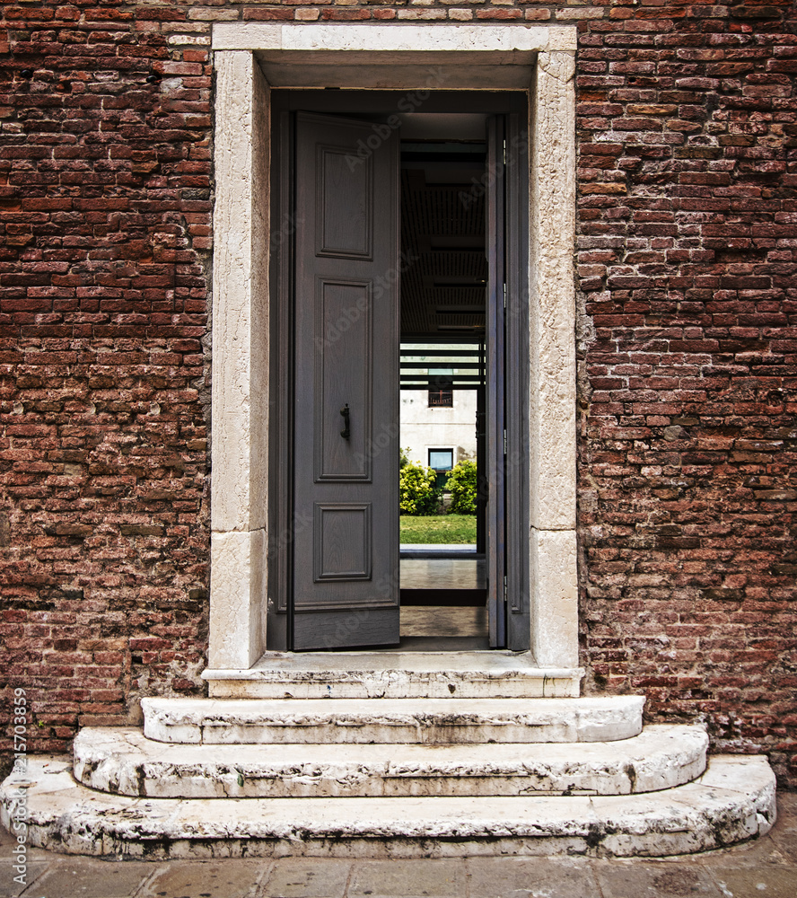 Steps to open door, doorway in old brick wall. Concept: way to the ...