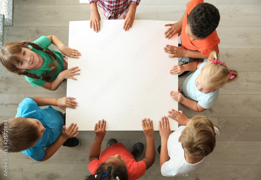 Little children holding sheet of paper in hands together indoors, top ...