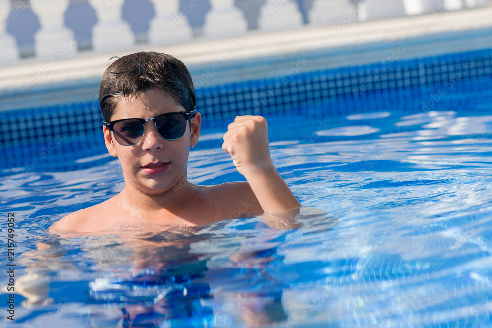 Young child on holiday at the swimming pool by the beach annoyed and ...