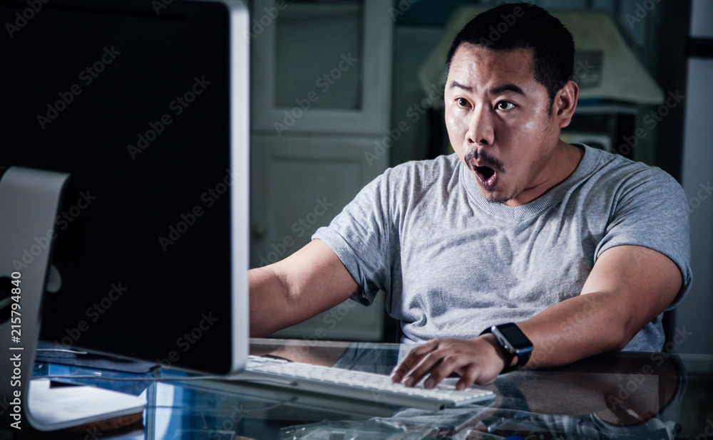 Asian Man feeling Wow! while using computer pc and enjoy herself while ...