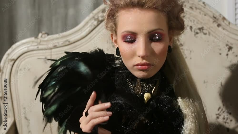 Close-up portrait of beautiful gothic lady. Woman in black feathers ...