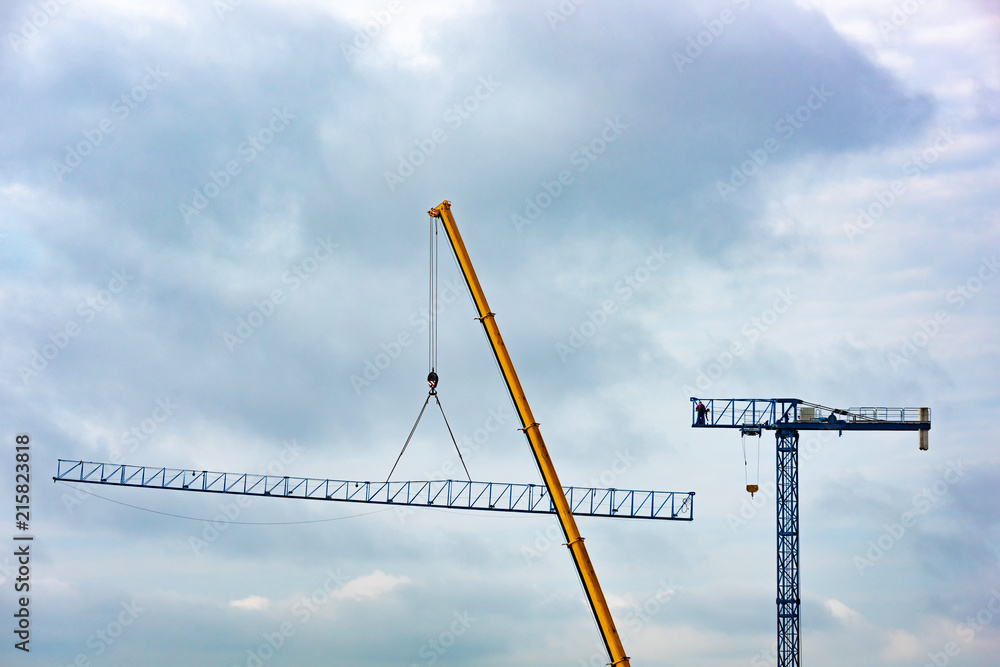 Setting up a blue tower crane in the construction site with a heavy ...