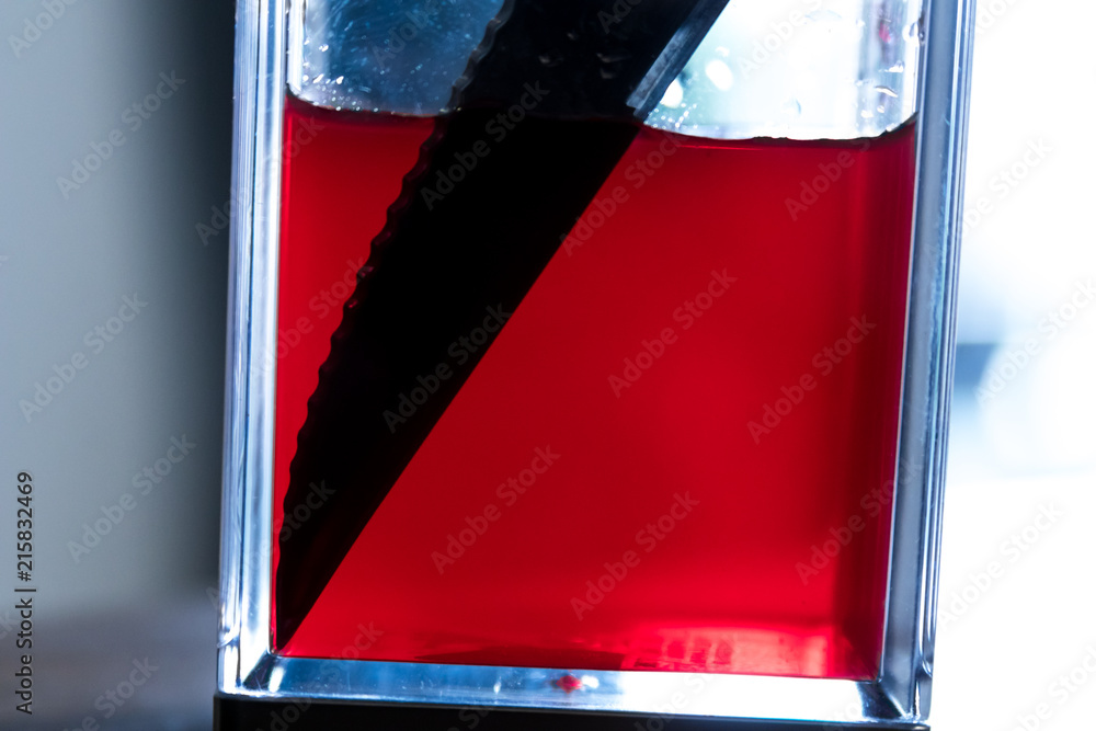 blood-red liquid in a transparent container illuminated from the back ...