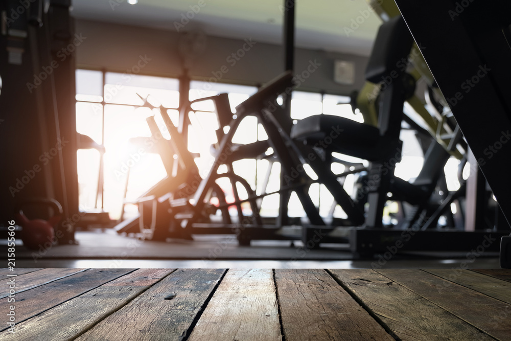 Empty desk space platform and fitness gym background with weight stack ...