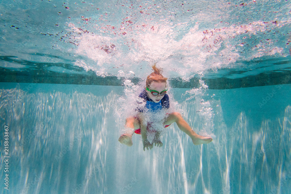 Boy jumping underwater in pool with bubbles Stock Photo | Adobe Stock