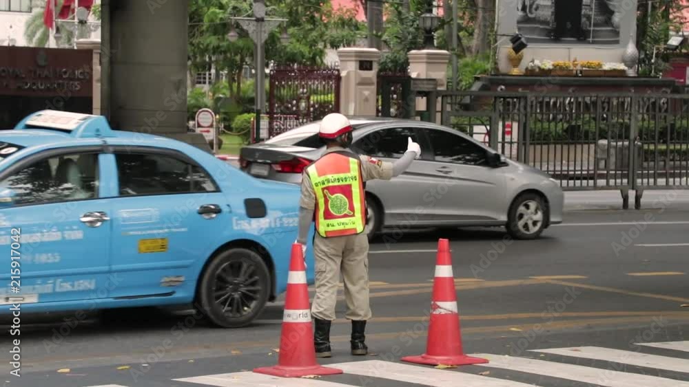 Police Officer Directs Cars in busy traffic In Bangkok สต็อกวิดีโอ | Adobe Stock