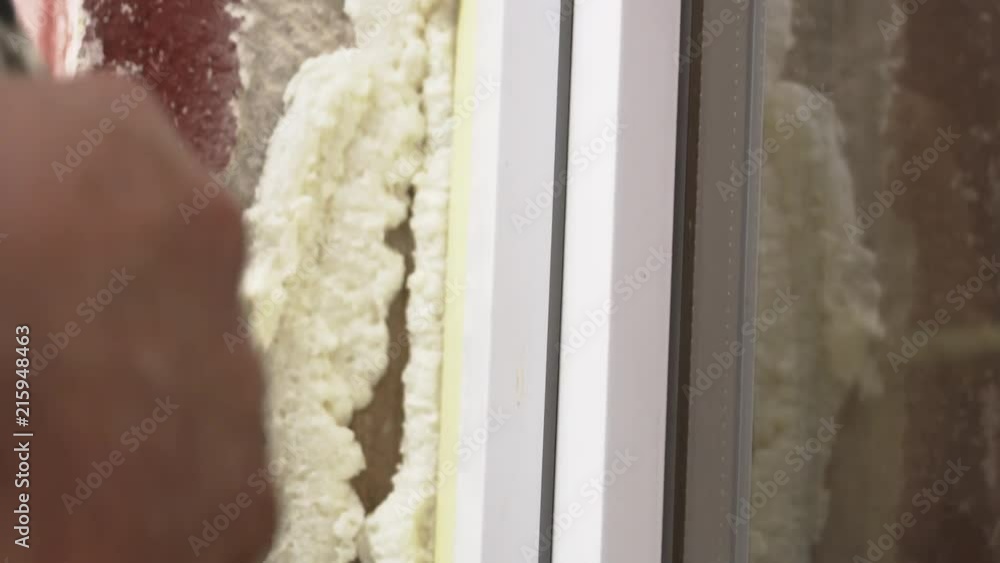A white and thick polyurethane foam on the window frame of a ...