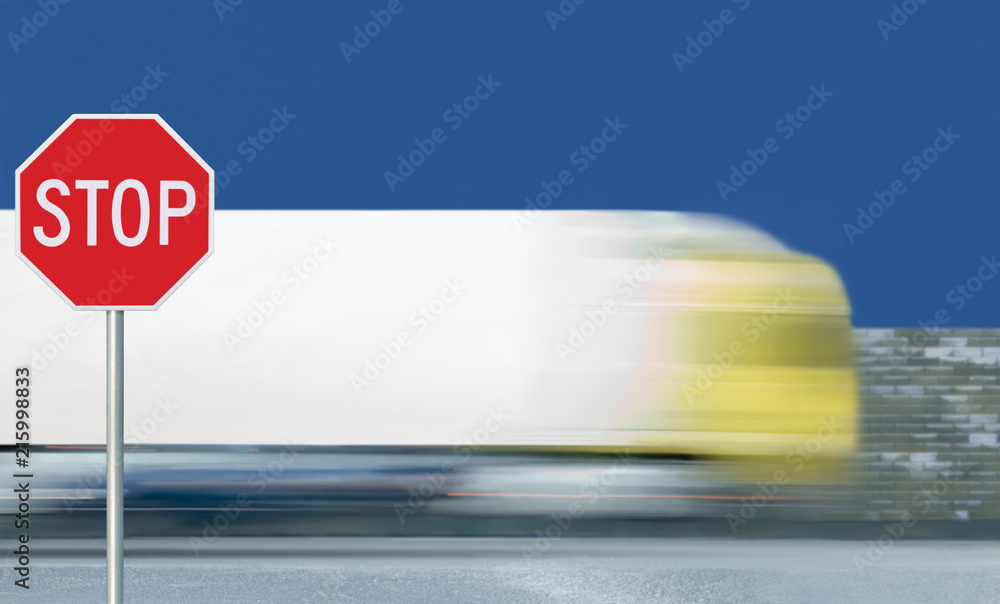 Red stop road sign, motion blurred truck vehicle traffic background ...