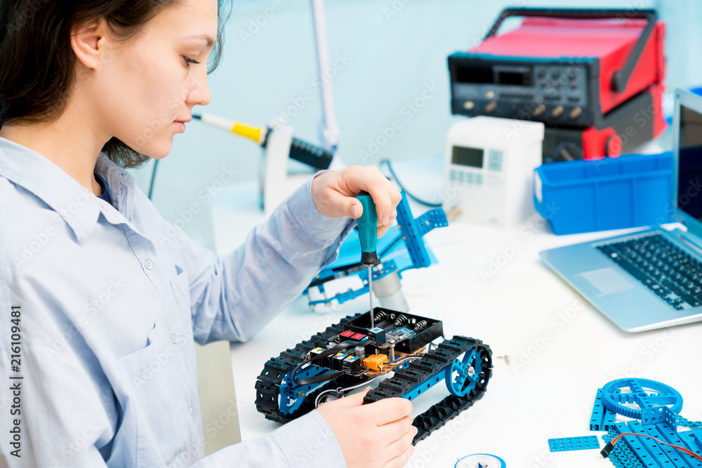 Student girl in electronics laboratory, experiment with microcontroller ...