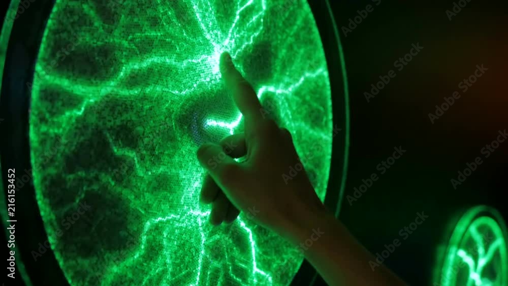 Interactive exposition in science museum. Woman touching plasma panel ...