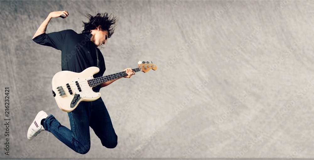 Portrait of a Musician Jumping while Playing Stock Photo | Adobe Stock