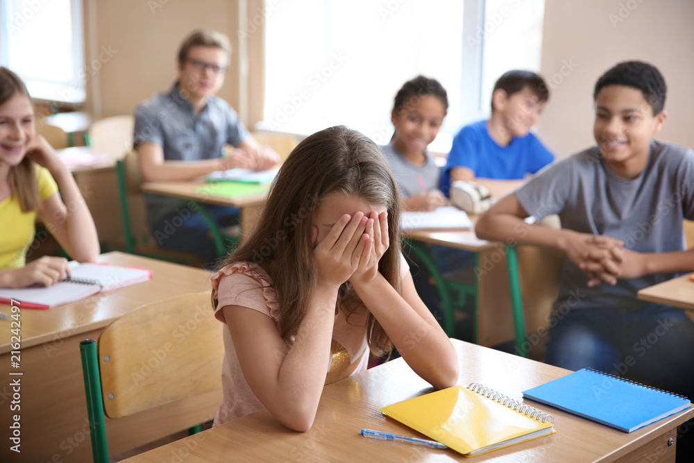 Sad girl sitting in classroom. Bullying at school Stock Photo | Adobe Stock