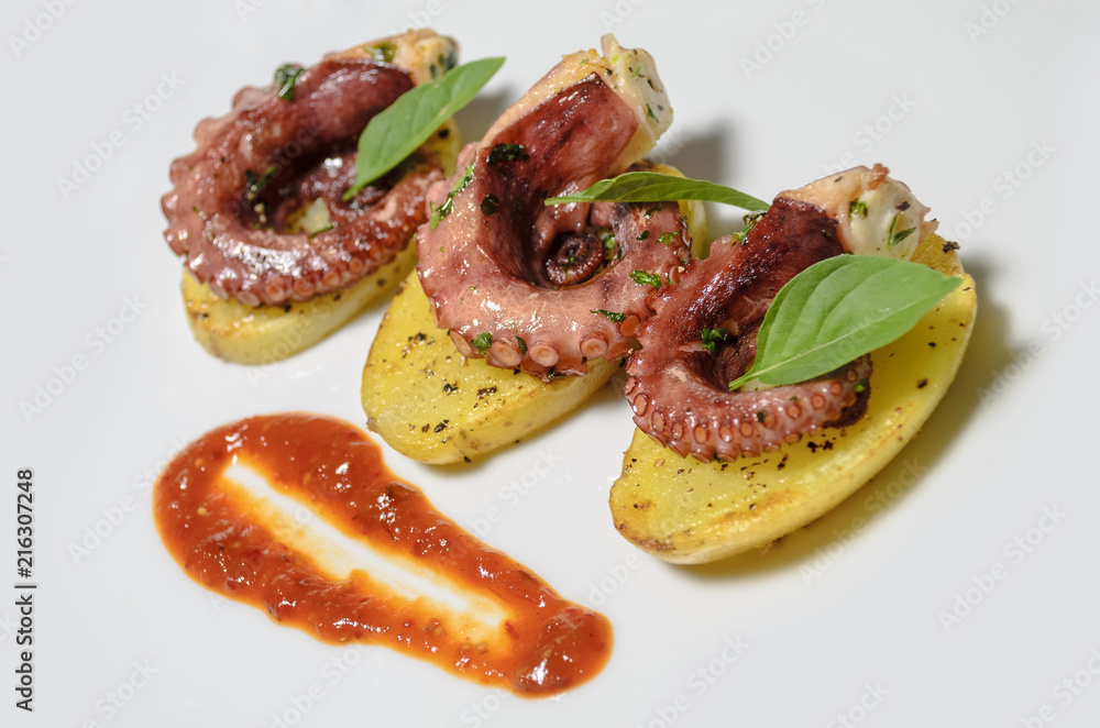 Platillo gourmet de pulpo con especias en una cama de patatas y salsa ...