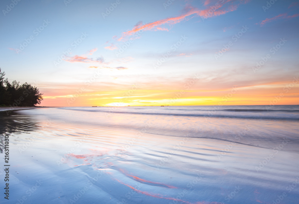 Beautiful and romantic sunset colour at the beach with reflection ...