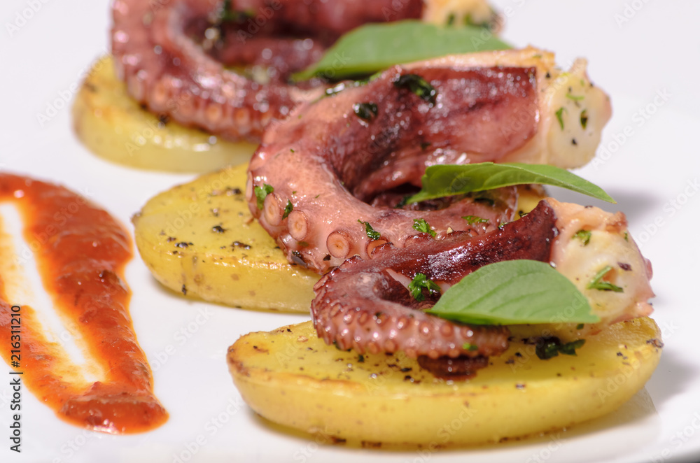 Platillo gourmet de pulpo con especias en una cama de patatas y salsa ...