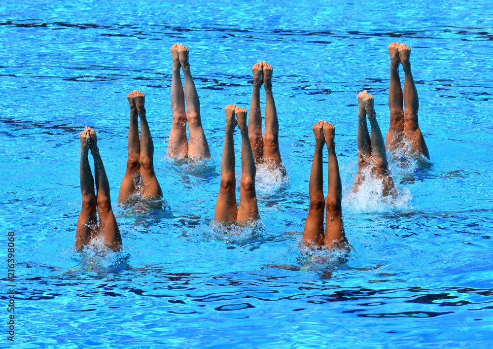 Synchronized Swimmers point up out of the water in action. Synchronized ... Synchronized Swimmers point up out of the water in action. Synchronized ...