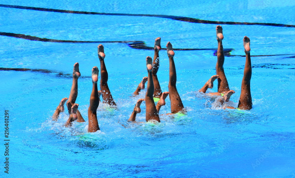 Synchronized Swimmers point up out of the water in action. Synchronized ... Synchronized Swimmers point up out of the water in action. Synchronized ...