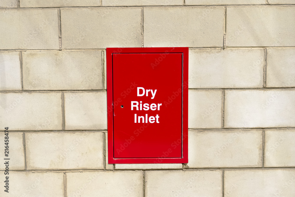 Dry riser inlet box red on brick wall for emergency fire services water ...