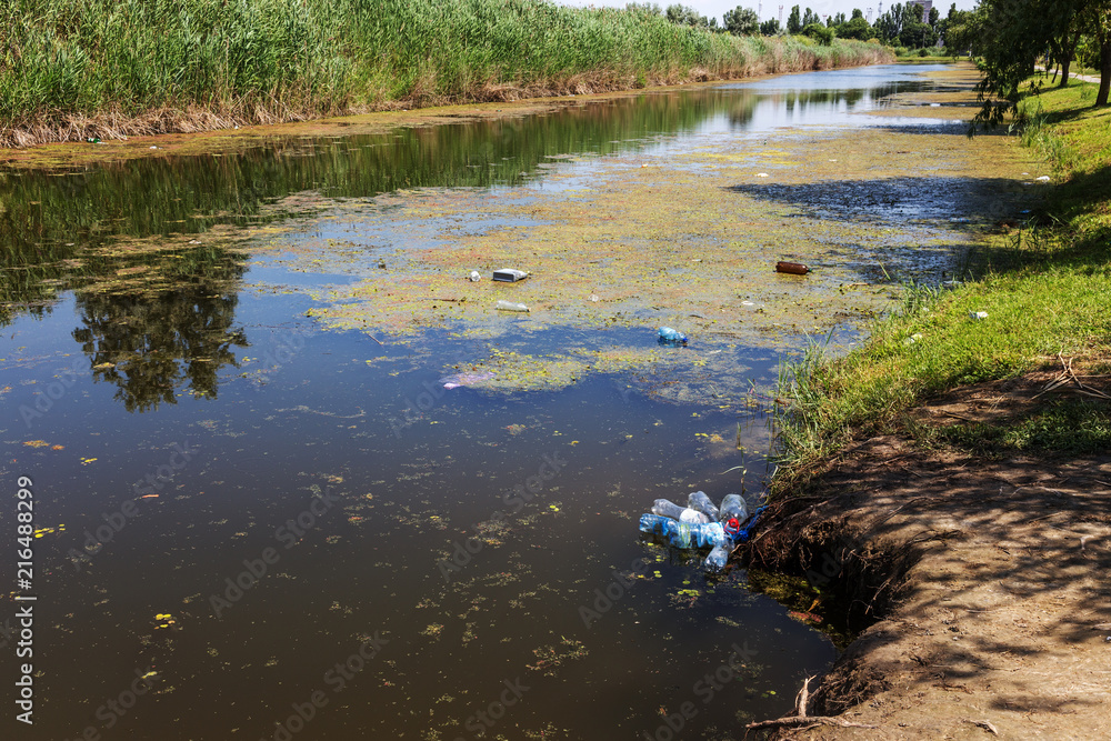 Dirty sewage and household rubbish in small river, irrigation channel ...