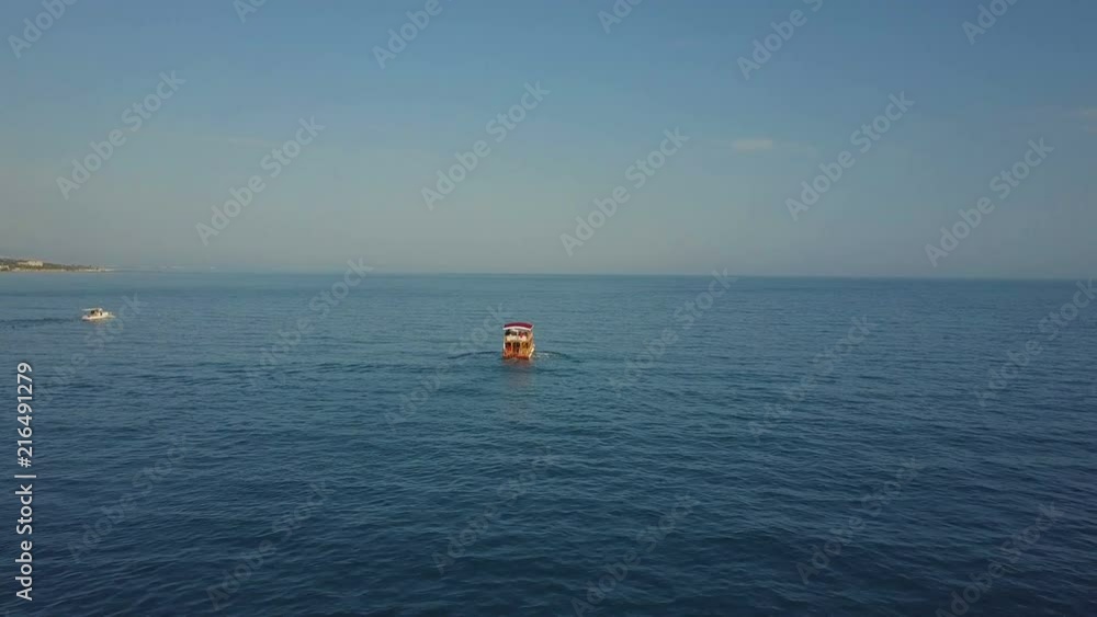 Drone is catching up with a floating ship. On the left there is a boat ...