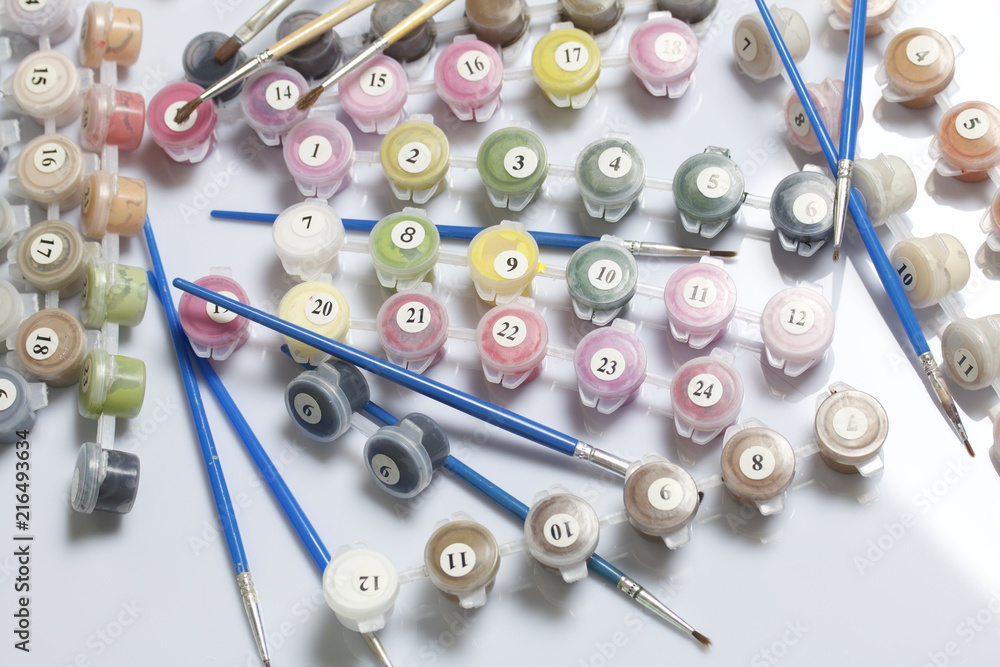 Numbered containers with paints and brushes of different sizes. For ...