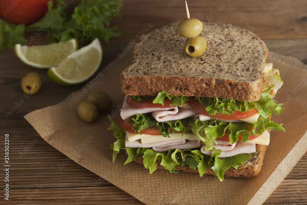 Double sandwich with ham, cheese, lettuce, tomato and green olives ...