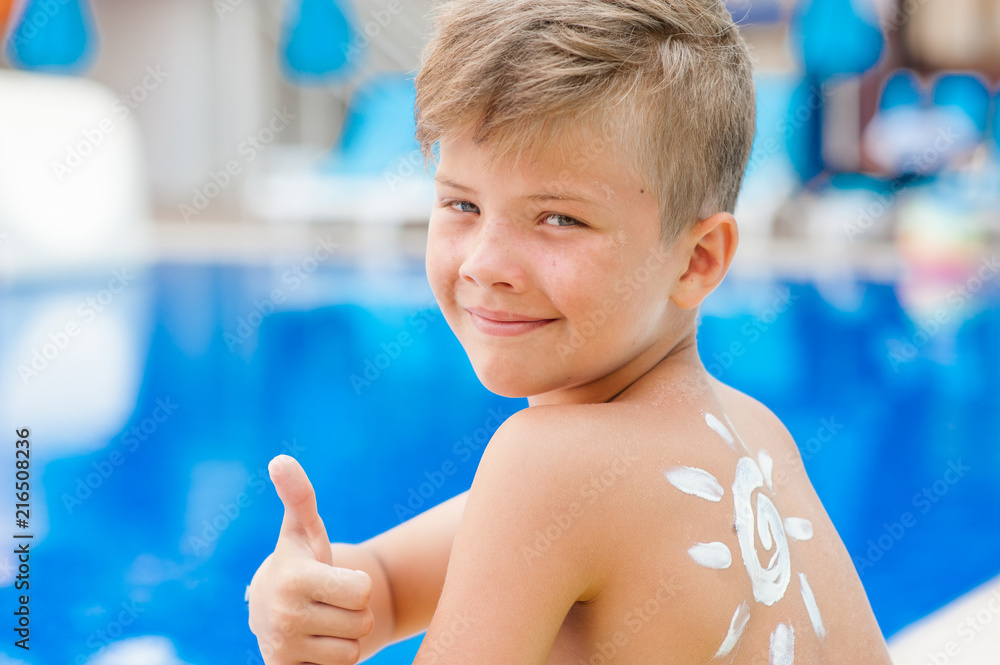 Happy boy with sun painted by sun cream on shoulder showing thumbs up ...