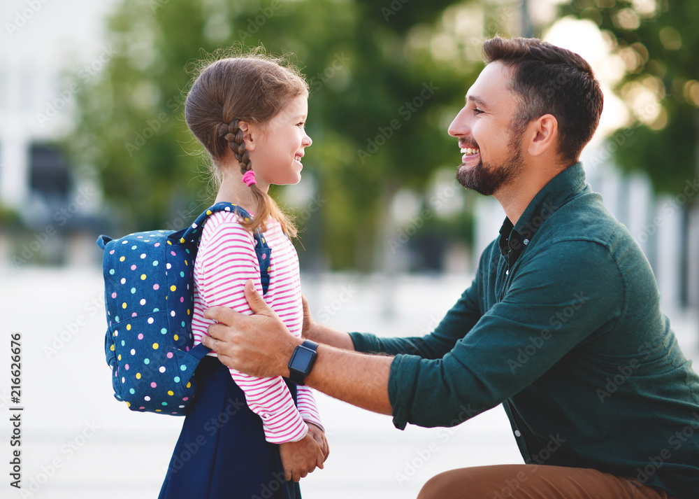 first day at school. father leads little child school girl in first ...