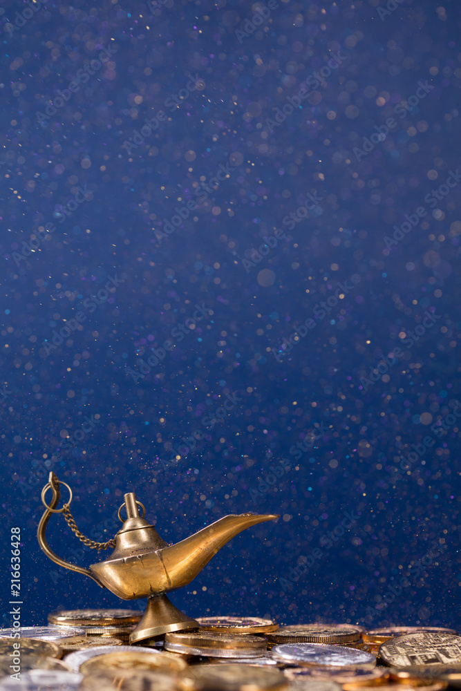 Magic lamp of wishes on stacks of gold coins with golden dust. Studio ...