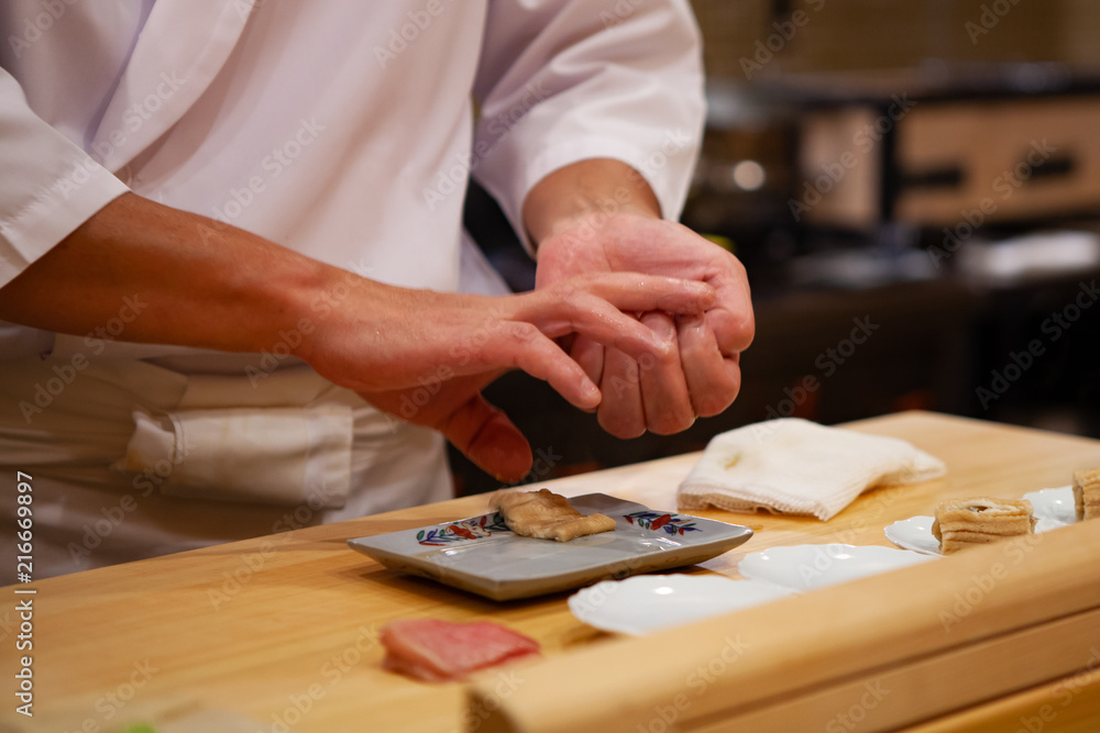 Professional sushi chef carefully using just the right pressure to make ...