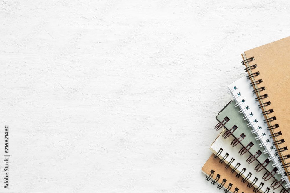 Top view of stack of spiral bound notebooks on gruge white wood desk ...