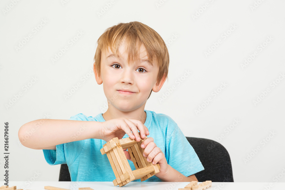 Cute boy playing with wooden blocks, isolated on white background ...