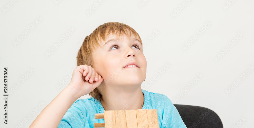 Cute little boy looks up against white background. Kid thinking ...