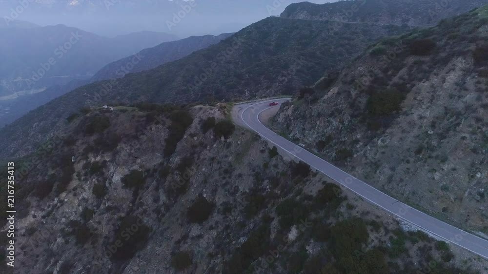 Early morning footage of some classic cars driving up a mountain road ...