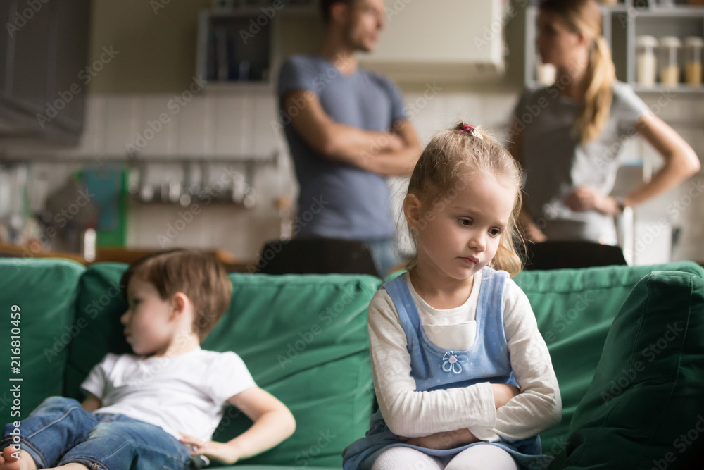 Upset little girl feeling sad after fight with brother sitting on sofa ...