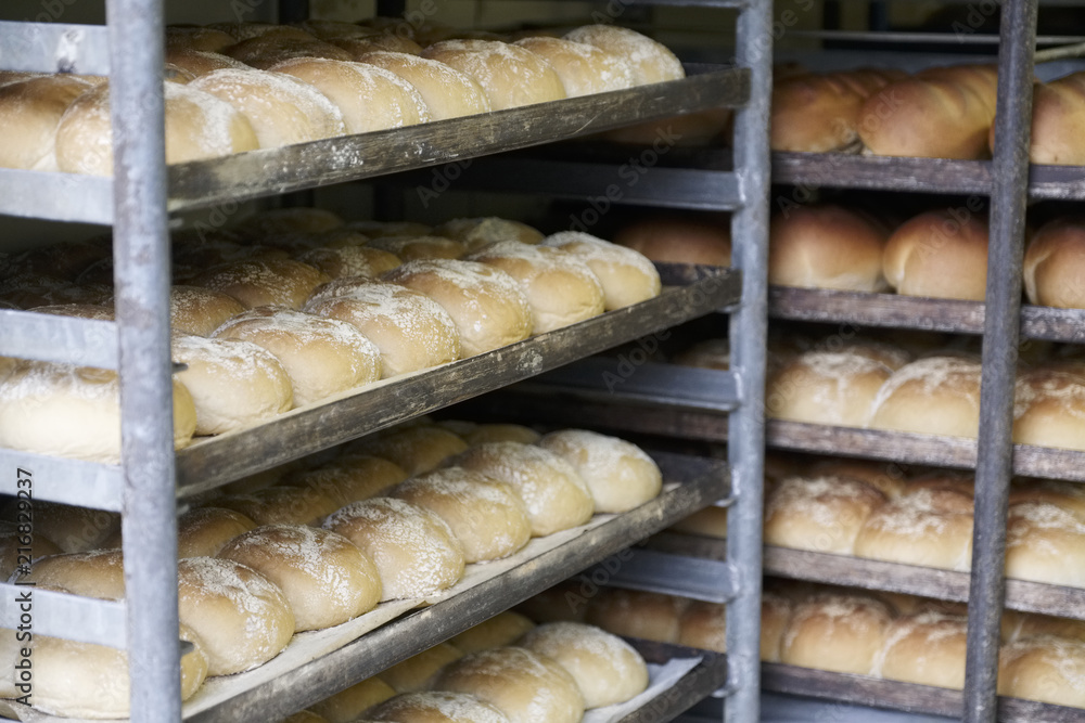 Stacked rows of multiple rolls and bread freshly baked by baker at ...