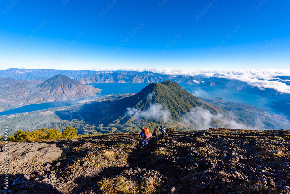 Hiker with panorama view of Lake Atitlan and volcano San Pedro and ...