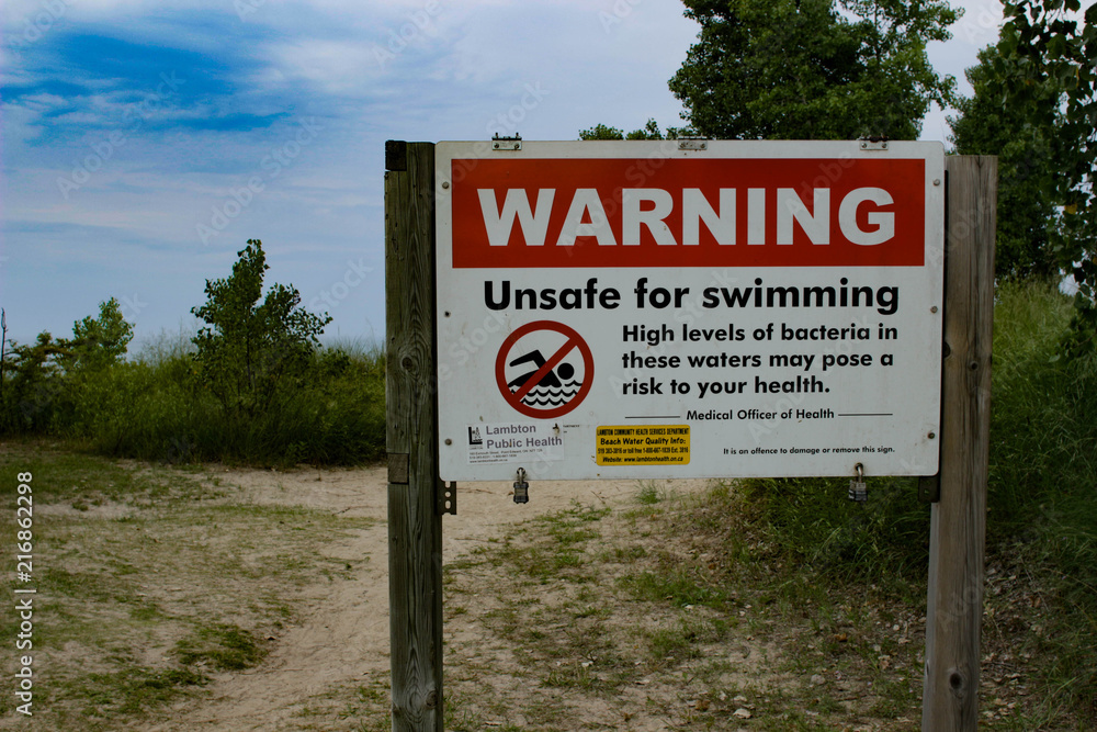 Warning sign at the Ipperwash beach in Southern Ontario. There is a ...