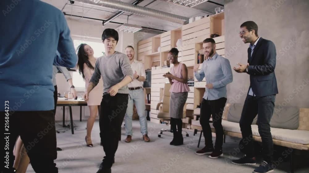 Happy Japanese employee doing funny dance moves at casual office ...