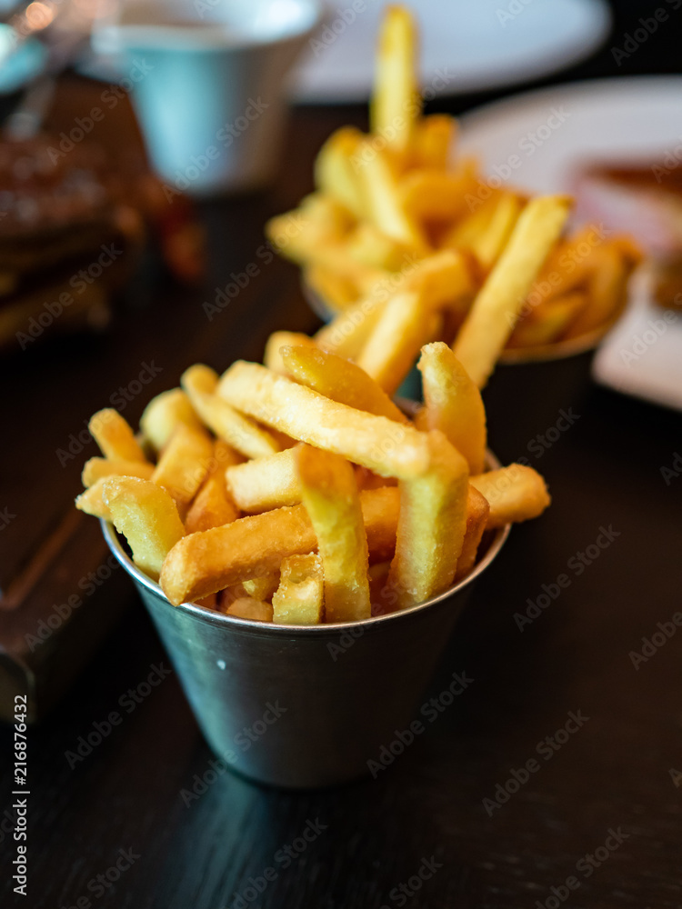 Pile of piping hot and crispy golden French fries or chips in a small ...
