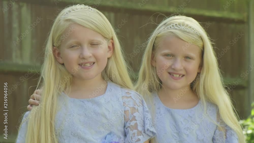 Portrait of pre teen twin caucasian girls looking at the camera themes ...