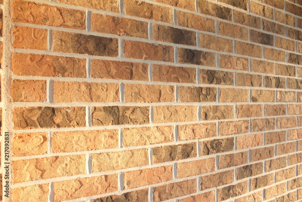 Textured brick wall background in varying colors of brown and tan ...