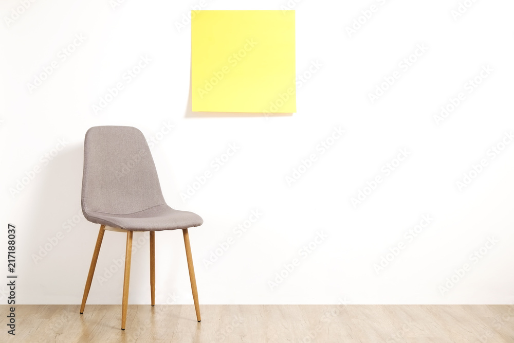 Single empty loft style gray chair on wooden floor, blank ad poster and ...