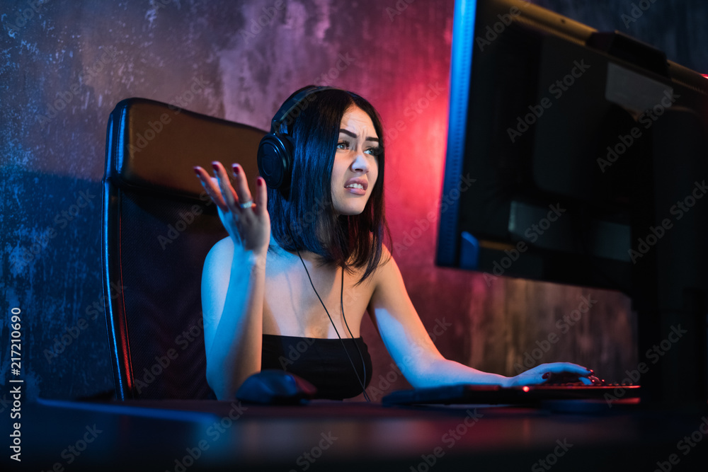 Terrified gamer plays games on your computer. An emotional young woman ...