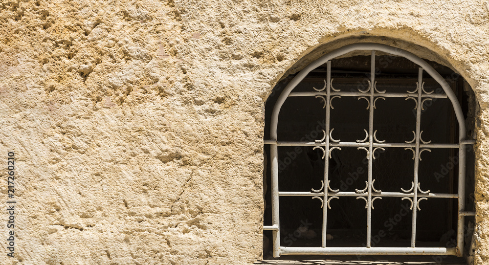 Old closed dirty window with metal bars on stone facade.Copy space ...