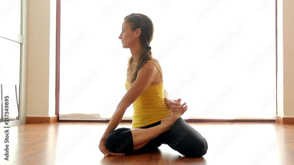 Video Stock Female yogi in bharadvajasana pose. Young woman practicing ...